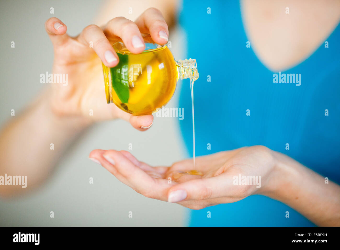 Woman using body oil Stock Photo - Alamy