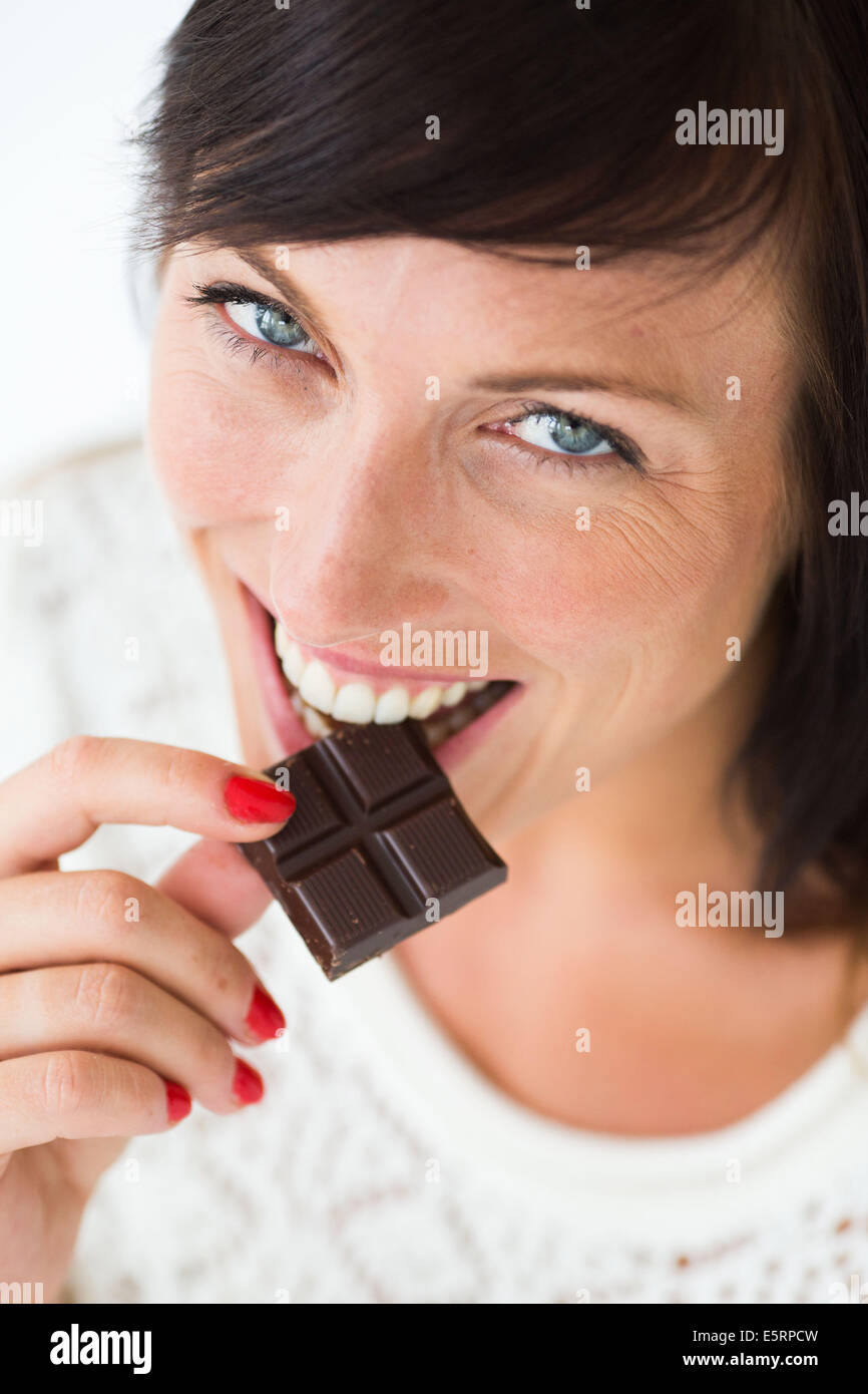 Woman eating chocolate Stock Photo - Alamy