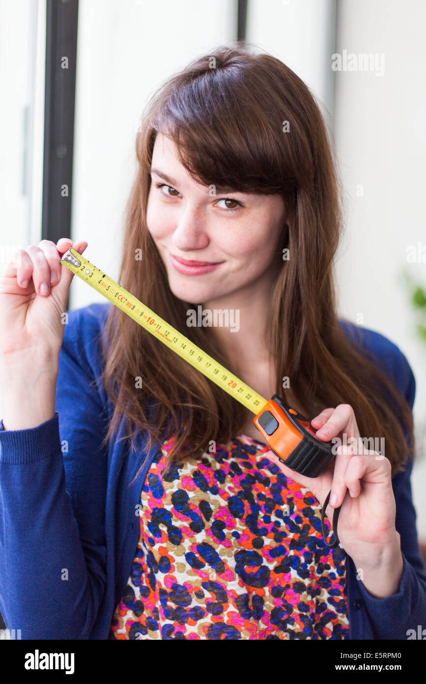 Do-it-yourself, Woman using tape measure Stock Photo - Alamy