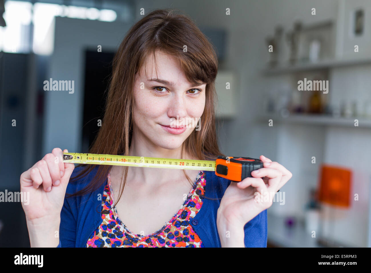 Do-it-yourself, Woman using tape measure Stock Photo - Alamy