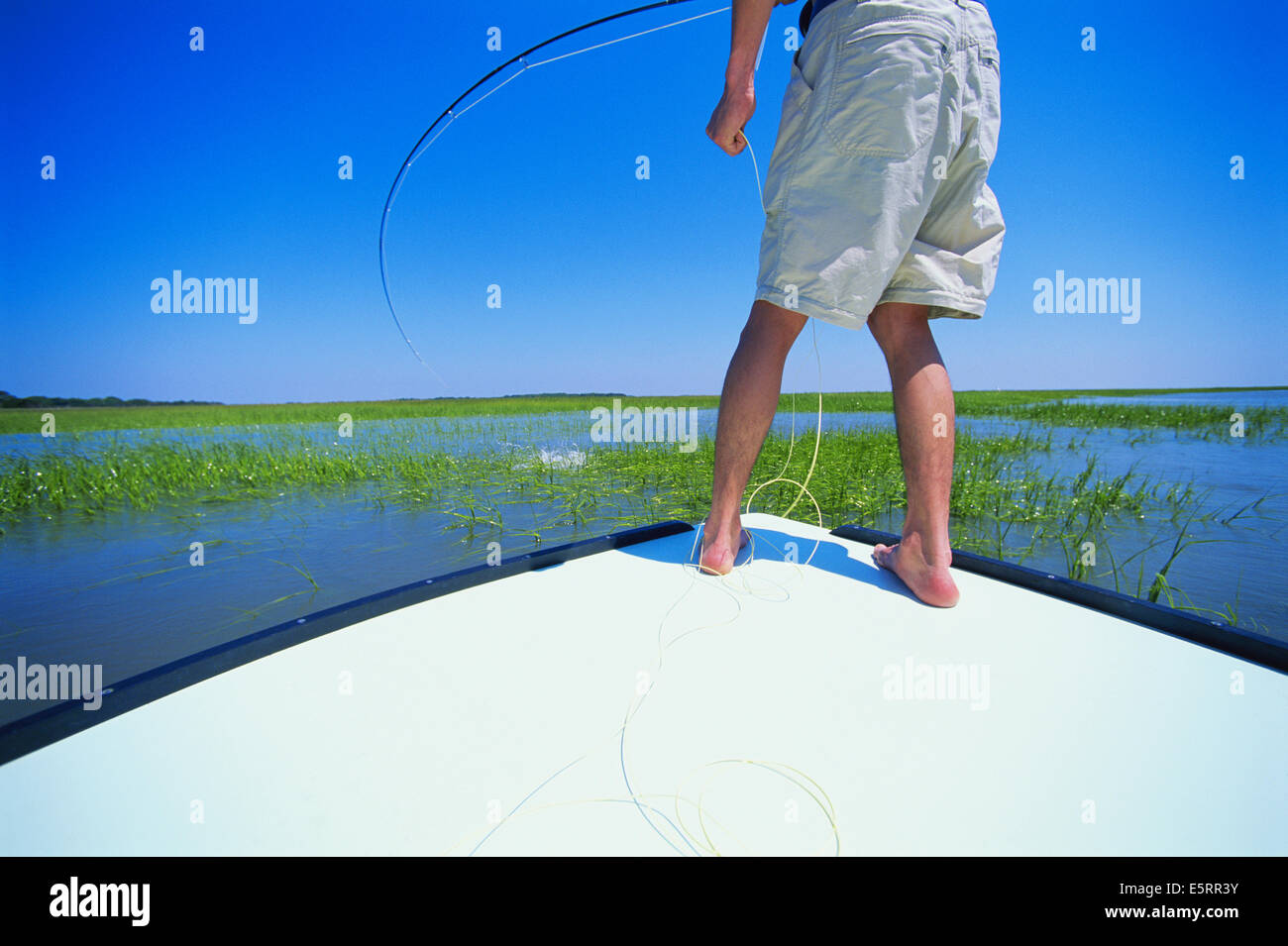 Fisherman reeling in catch, low section Stock Photo - Alamy
