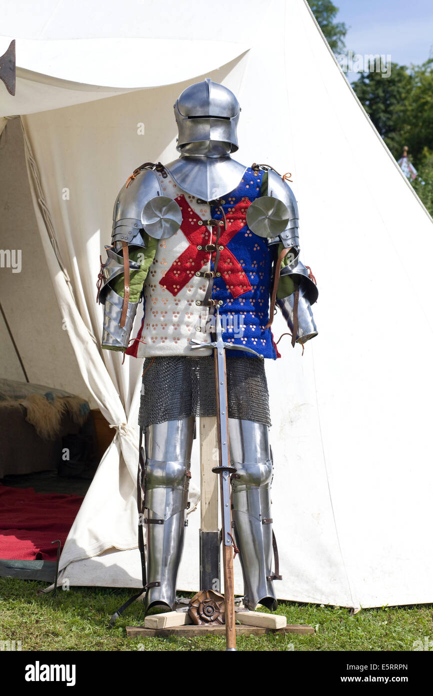 Knights armor with sword standing against a white tent Stock Photo - Alamy