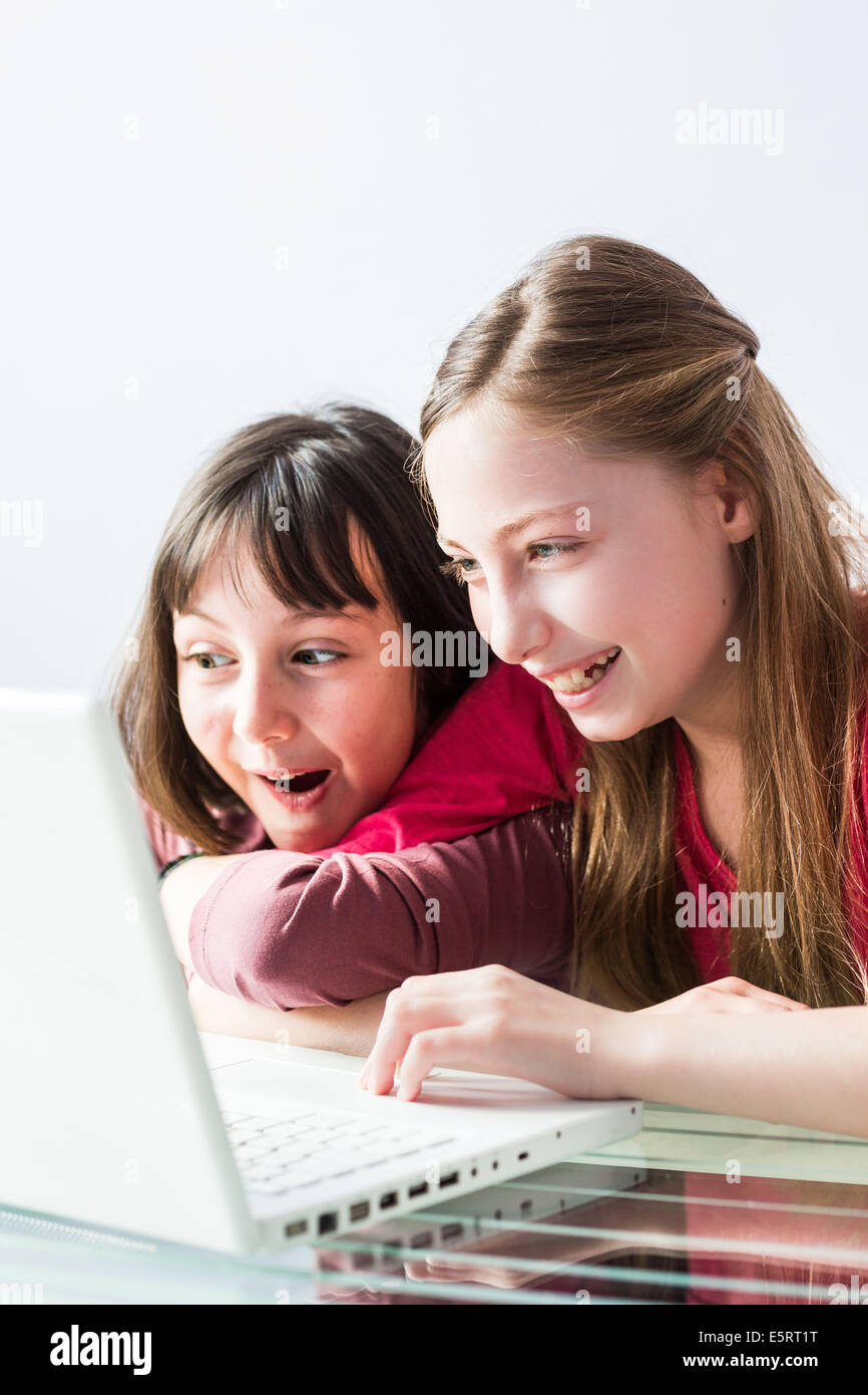 Sisters using laptop computer Stock Photo - Alamy