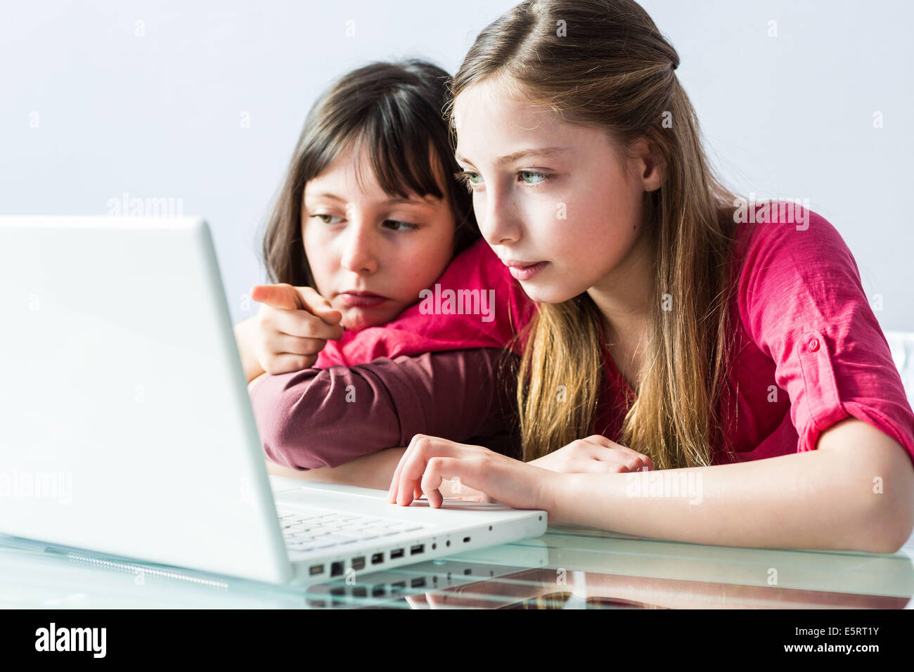 Sisters using laptop computer Stock Photo - Alamy