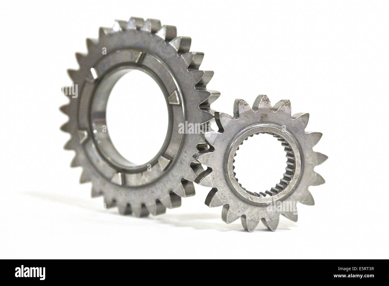 Two metal cog wheels interlocked together Stock Photo - Alamy