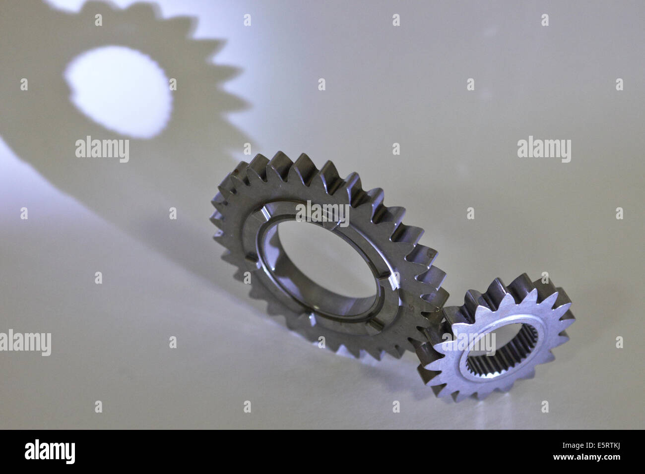 Two metal cog wheels interlocked together Stock Photo - Alamy