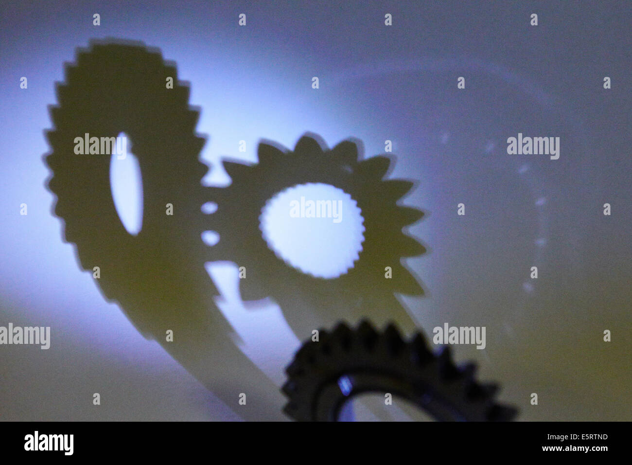 Two metal cog wheels interlocked together Stock Photo - Alamy