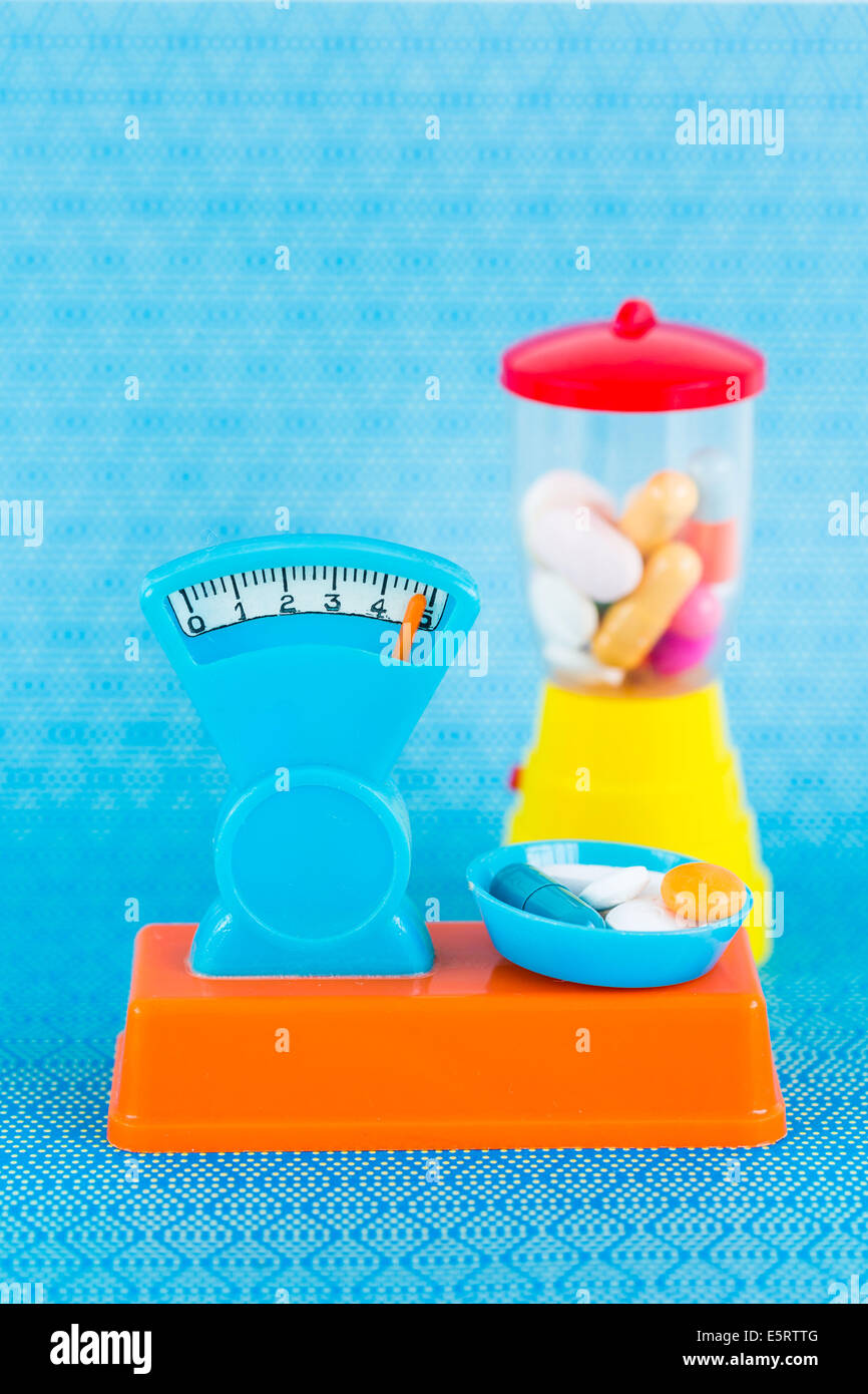 Slimming pills on weight scale Stock Photo - Alamy