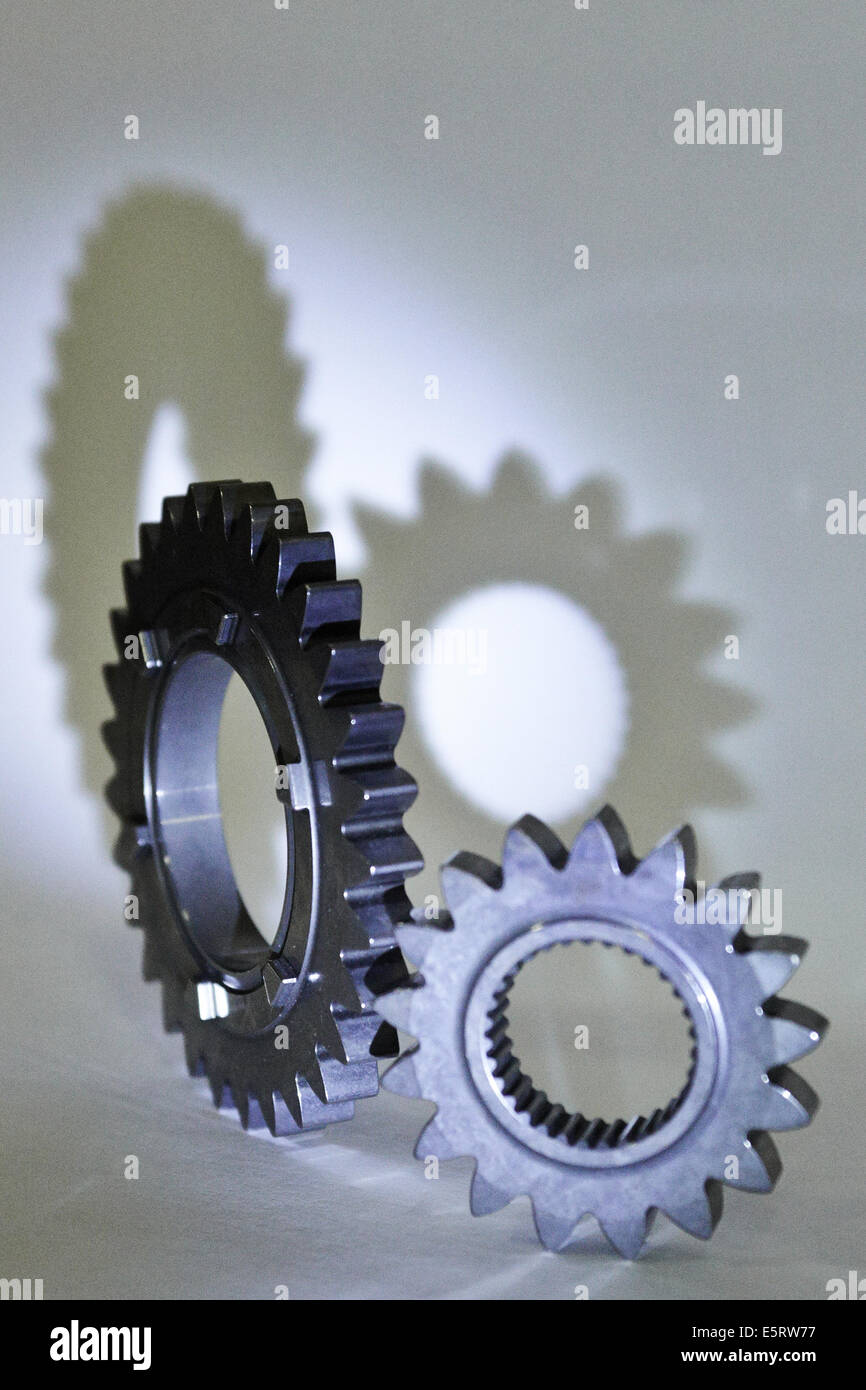 Two metal cog wheels interlocked together Stock Photo - Alamy