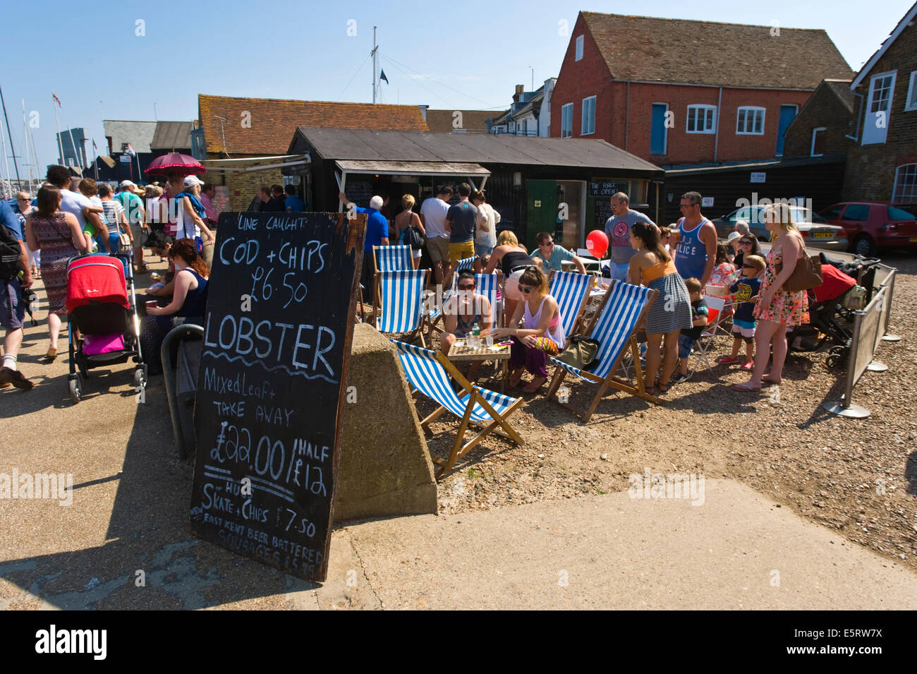 Tourists eating at beachfront seafood outdoor cafe during Whitstable ...
