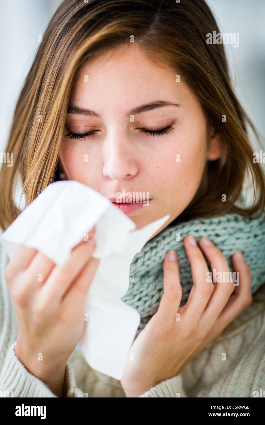 Woman with a cold using tissue Stock Photo - Alamy