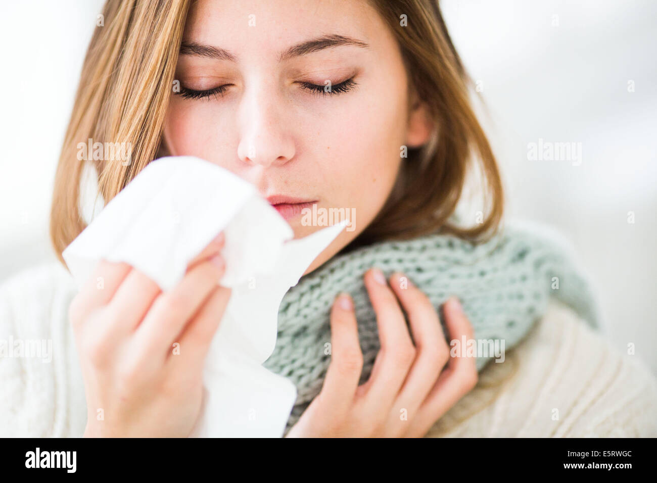 Woman with a cold using tissue Stock Photo - Alamy