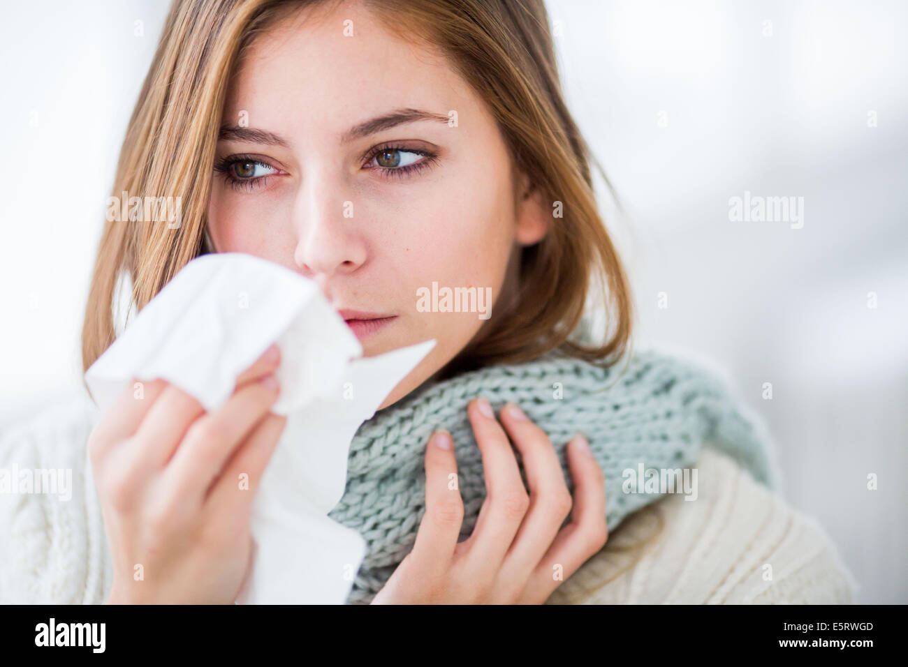 Woman with a cold using tissue Stock Photo - Alamy