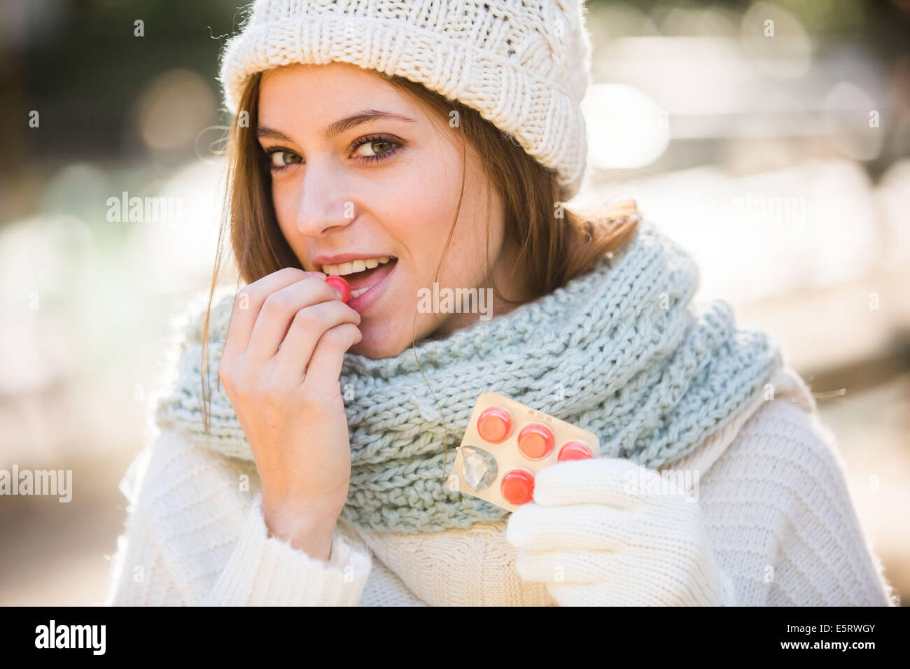 Woman taking lozenge for sorethroat Stock Photo - Alamy