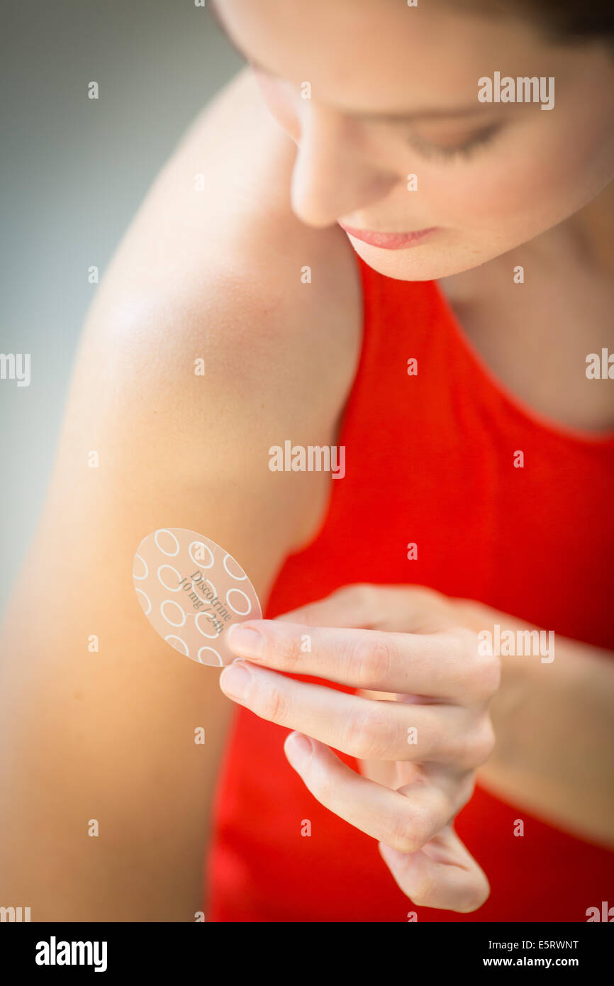 Woman applying a patch in prevention of angina pectoris Stock Photo - Alamy