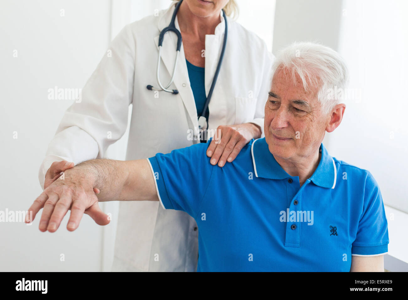 Doctor examining arm of elderly patient Stock Photo - Alamy