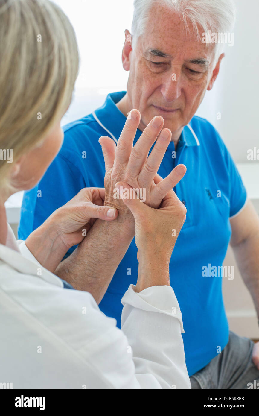 Doctor examining the hand of elderly man Stock Photo - Alamy