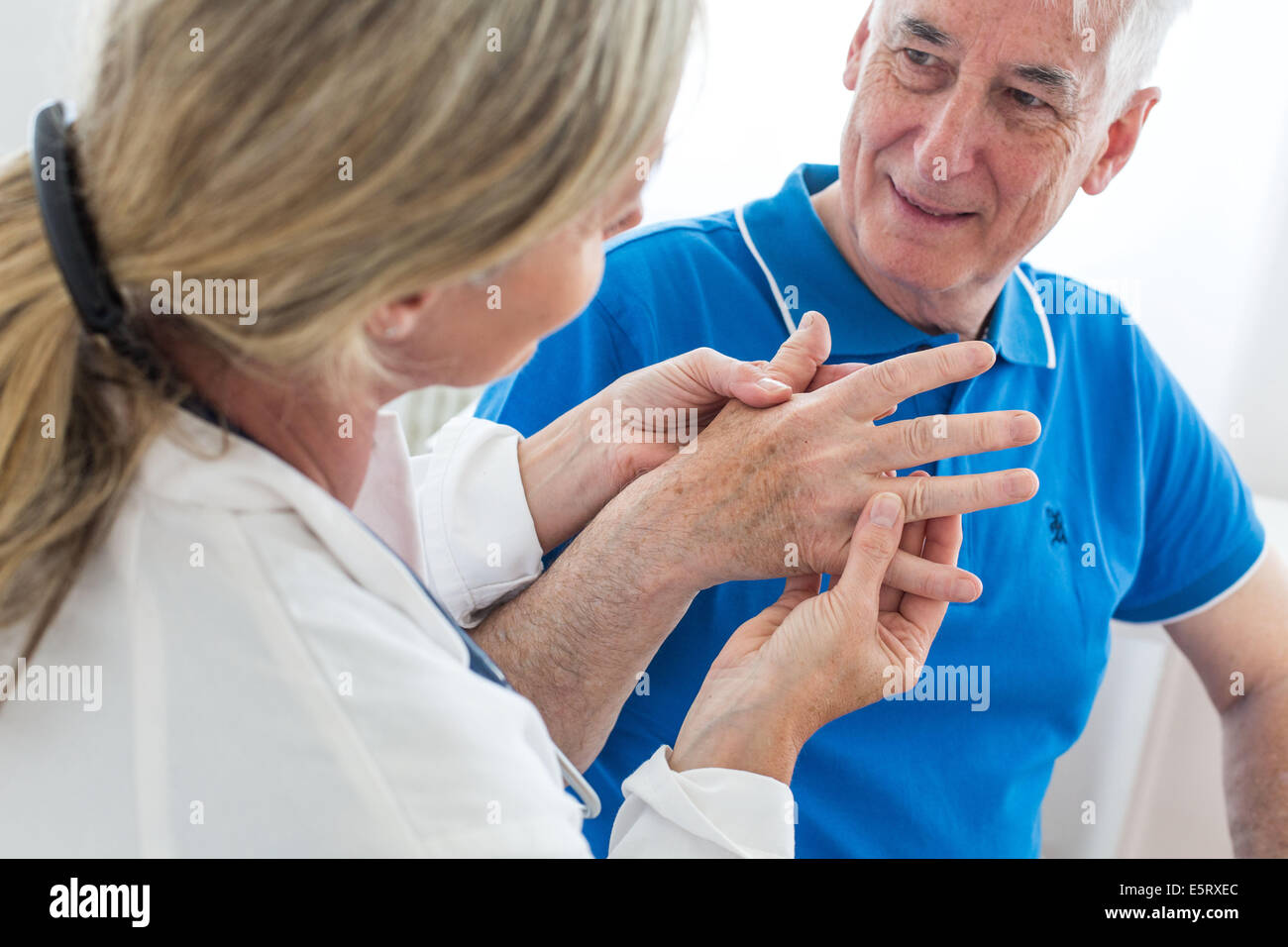 Doctor examining the hand of elderly man Stock Photo - Alamy