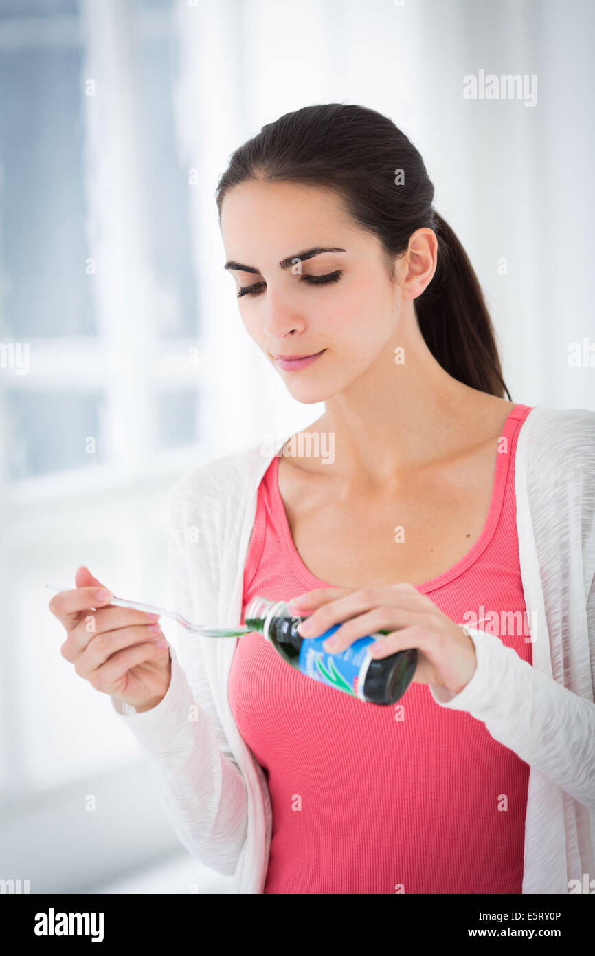 Woman taking syrup Stock Photo - Alamy