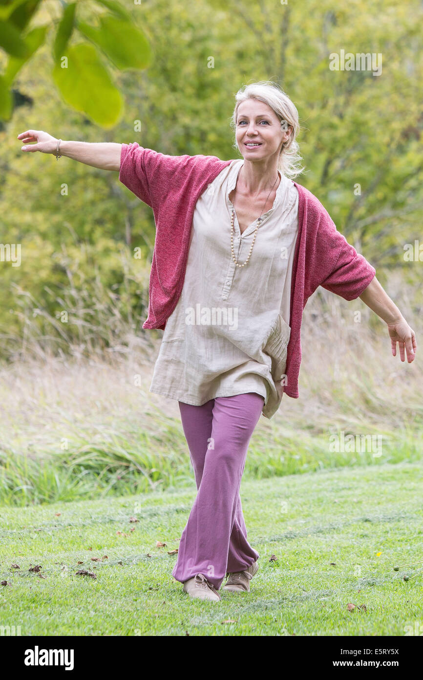Woman walking through meadow Stock Photo - Alamy