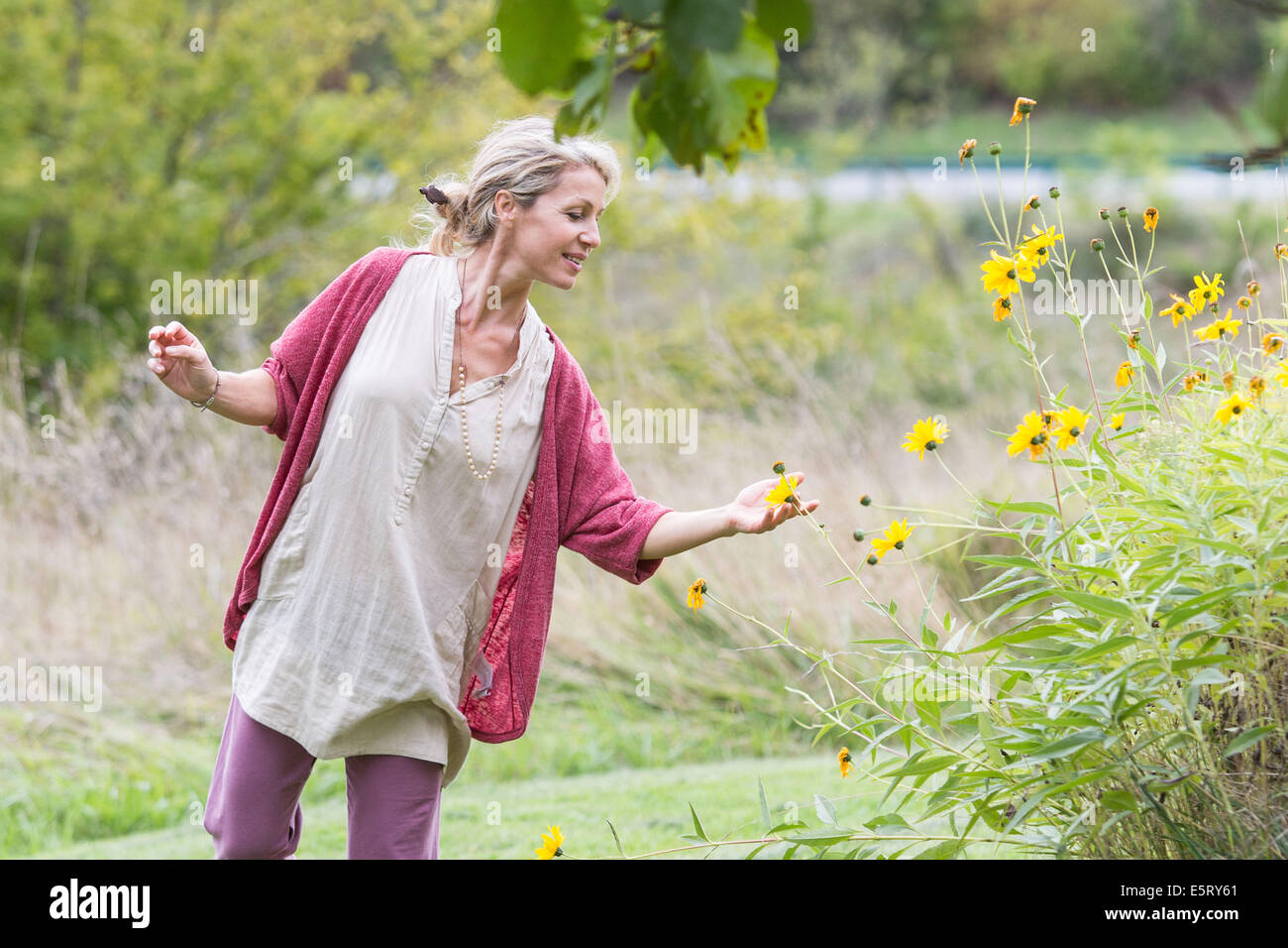 Woman walking through meadow Stock Photo - Alamy