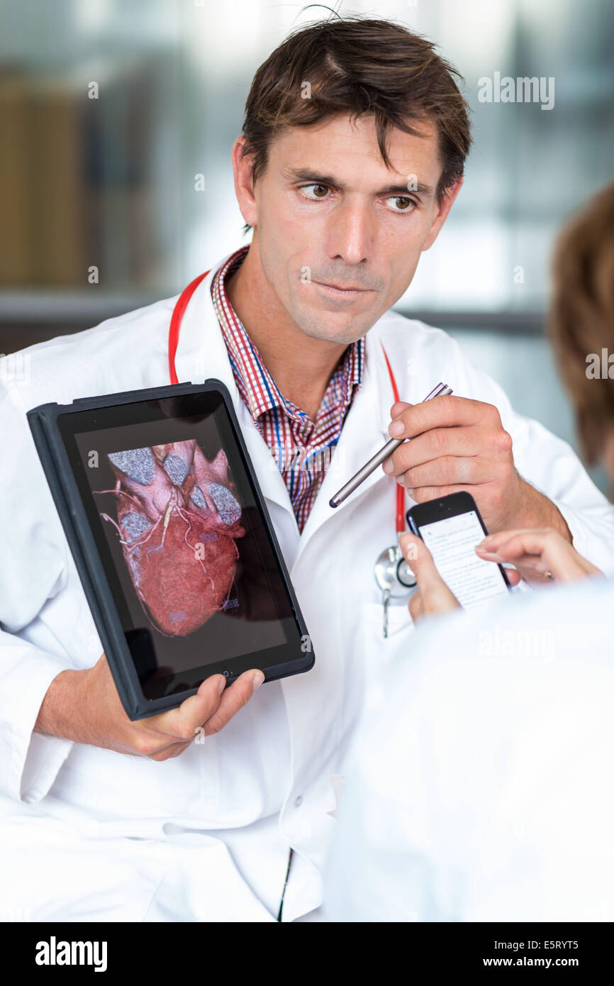 Doctors using a tablet PC and Iphone® Stock Photo - Alamy