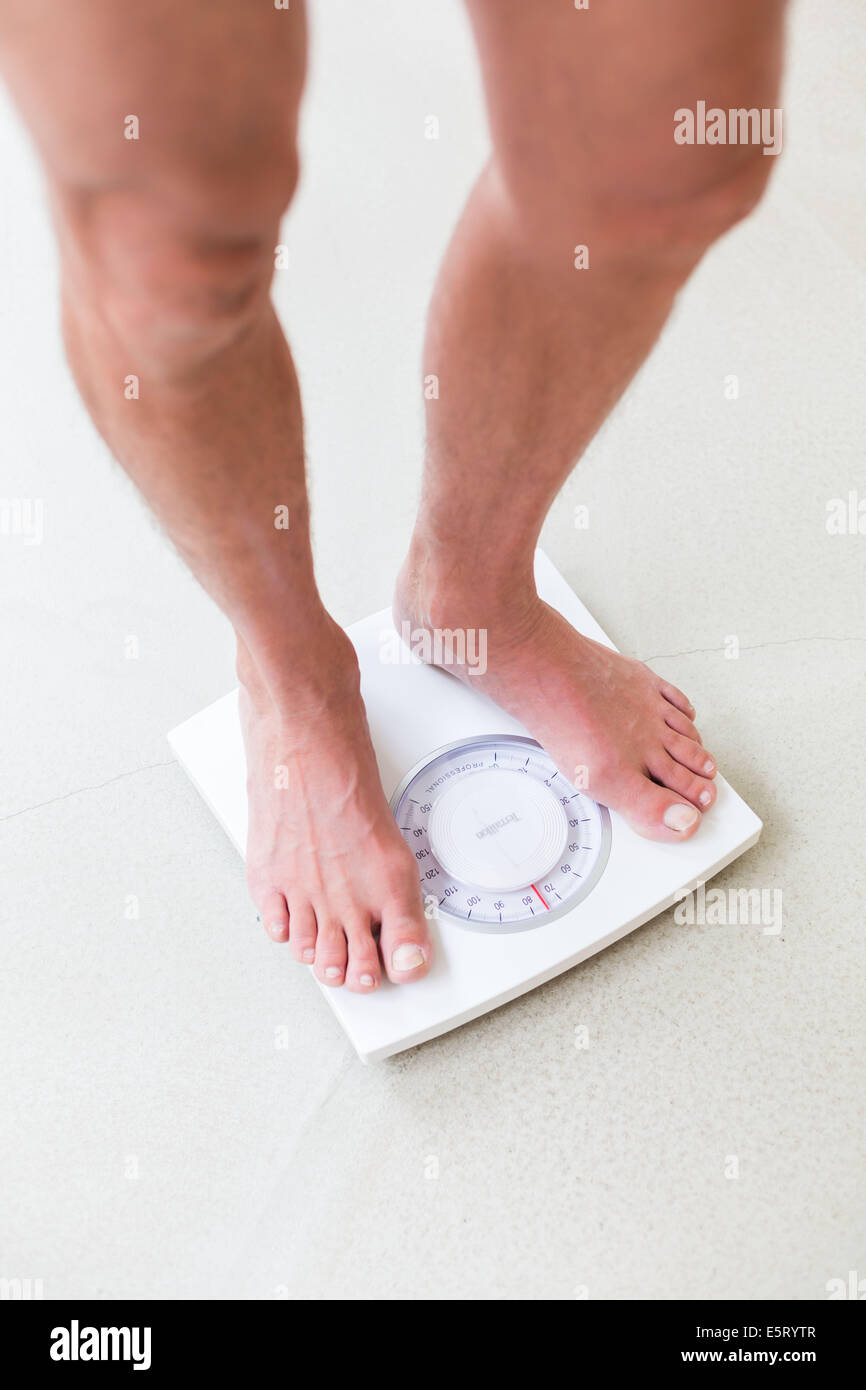 Man on a scale Stock Photo - Alamy