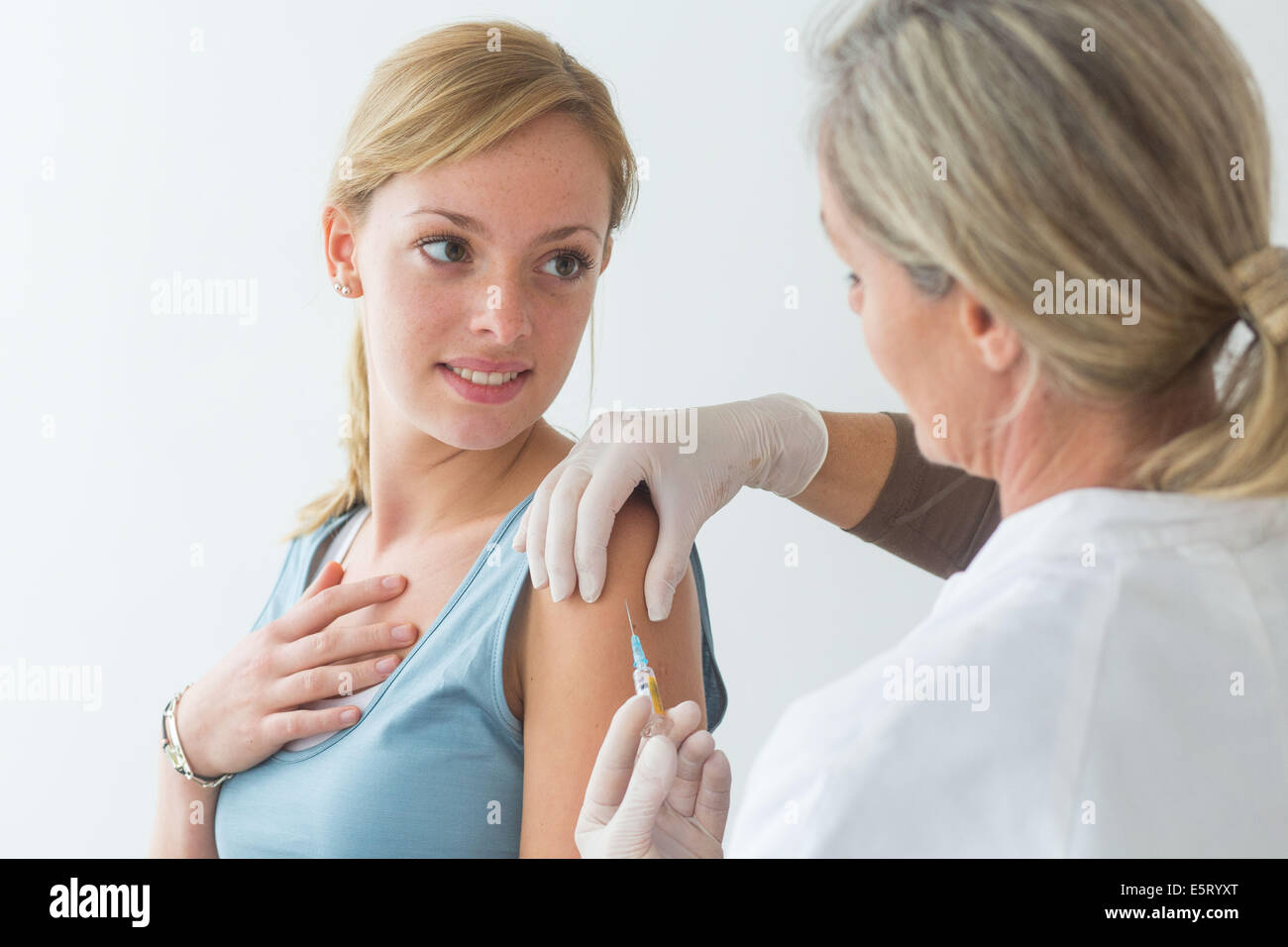 Young woman receiving vaccination Stock Photo - Alamy