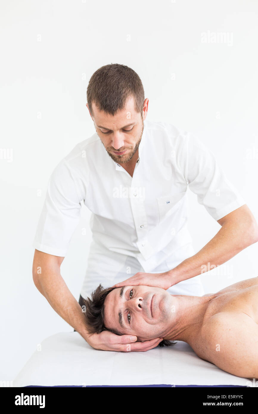 Structural osteopathy session in a man suffering from neck pain Stock ...