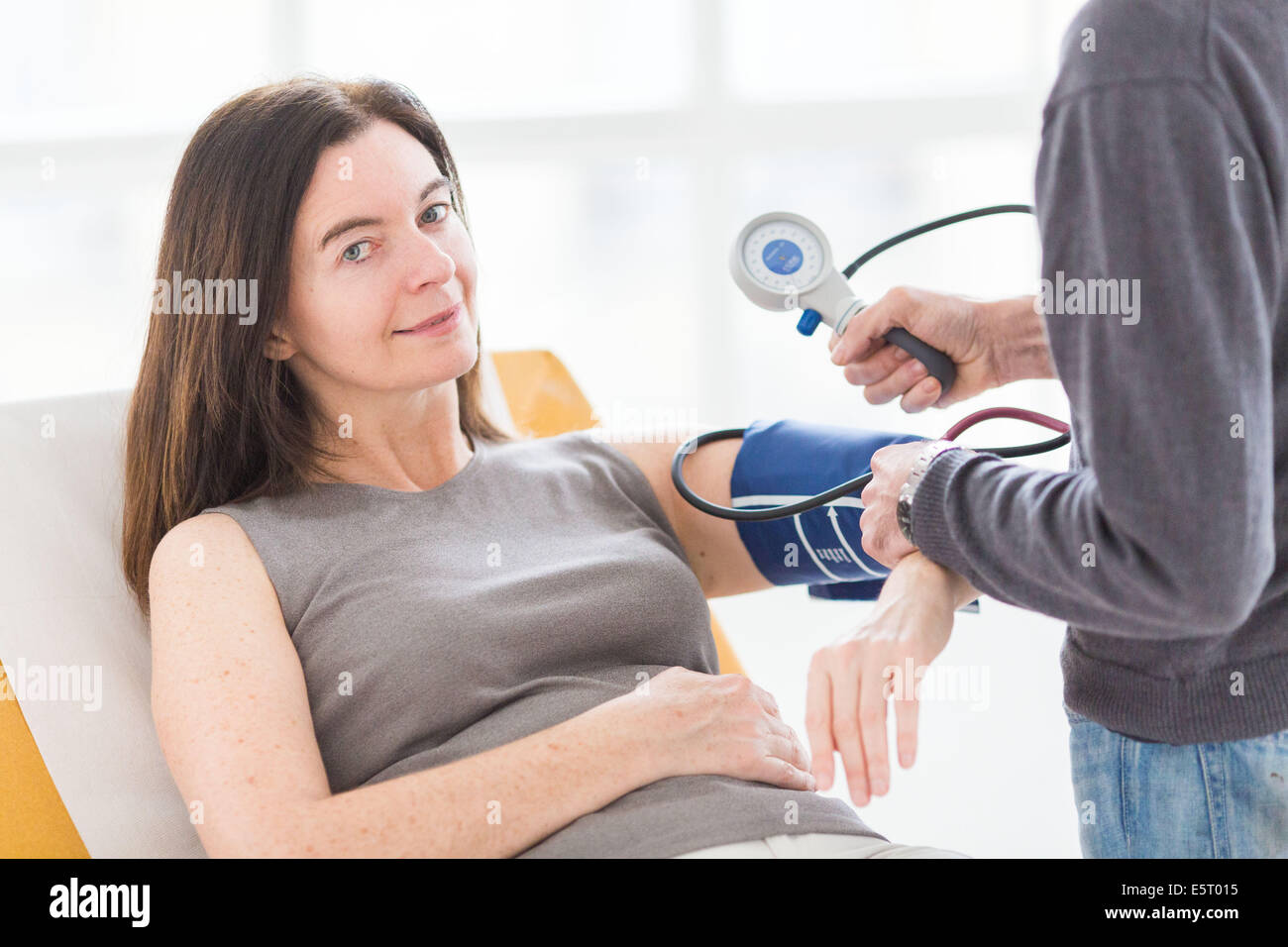 Doctor checking the blood pressure of a woman Stock Photo - Alamy