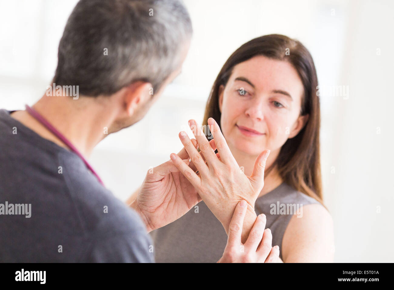 Doctor examining hand of a patient Stock Photo - Alamy
