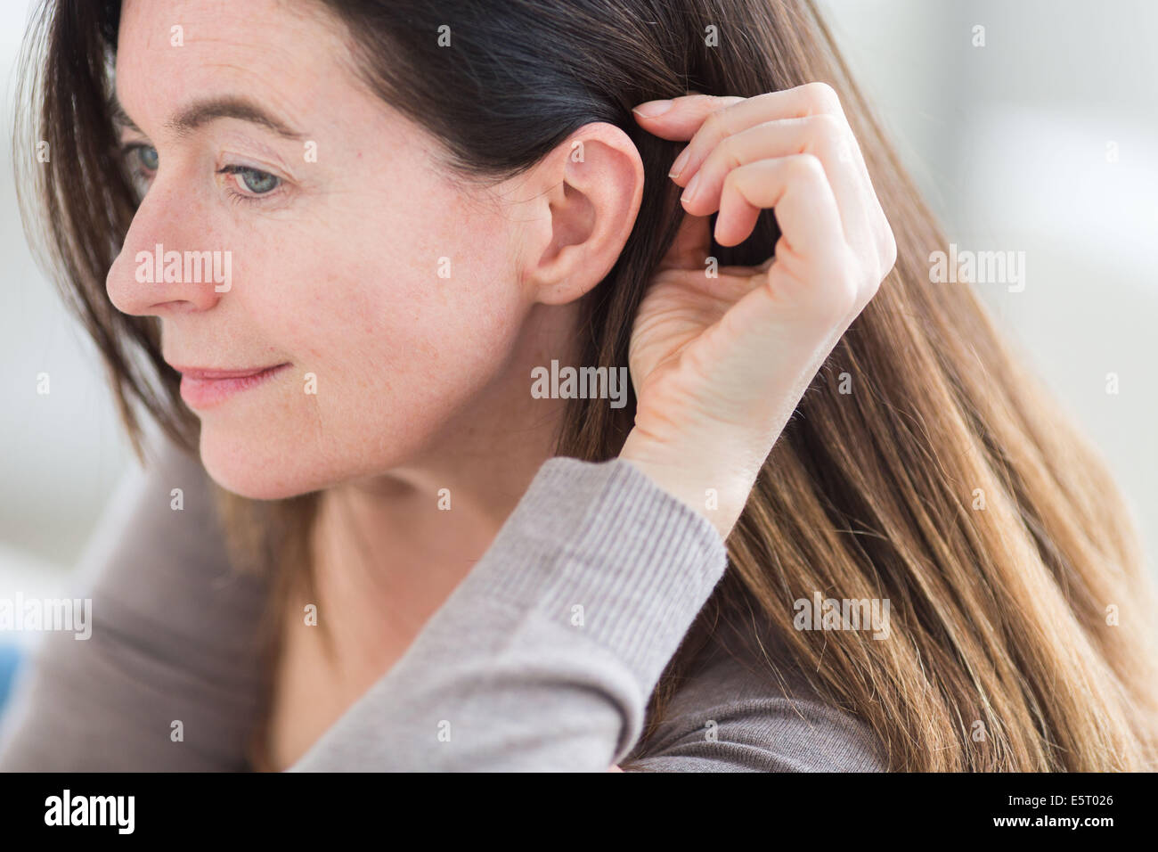 Woman with her hand to her ear Stock Photo - Alamy