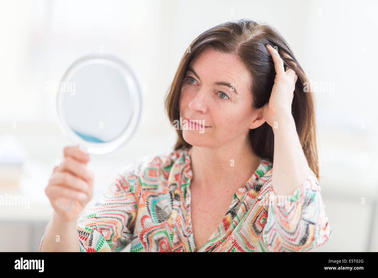 Woman checking checking her face in the mirror Stock Photo - Alamy