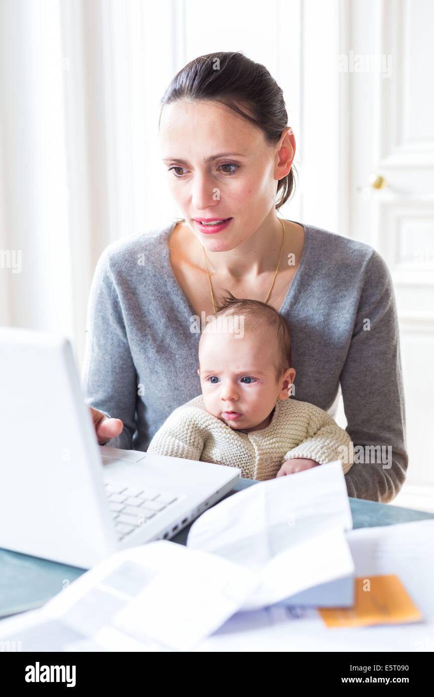 Woman using laptop computer with her 3 month old baby boy Stock Photo ...