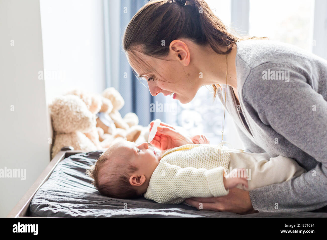 3 month old baby boy having his nose cleared with physiological saline ...