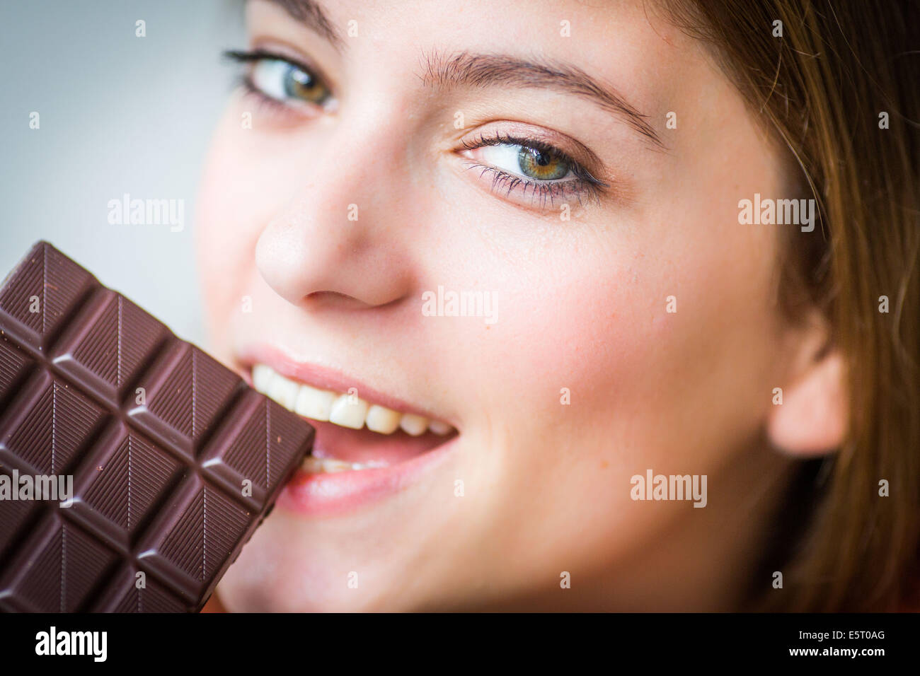 Woman eating chocolate Stock Photo - Alamy