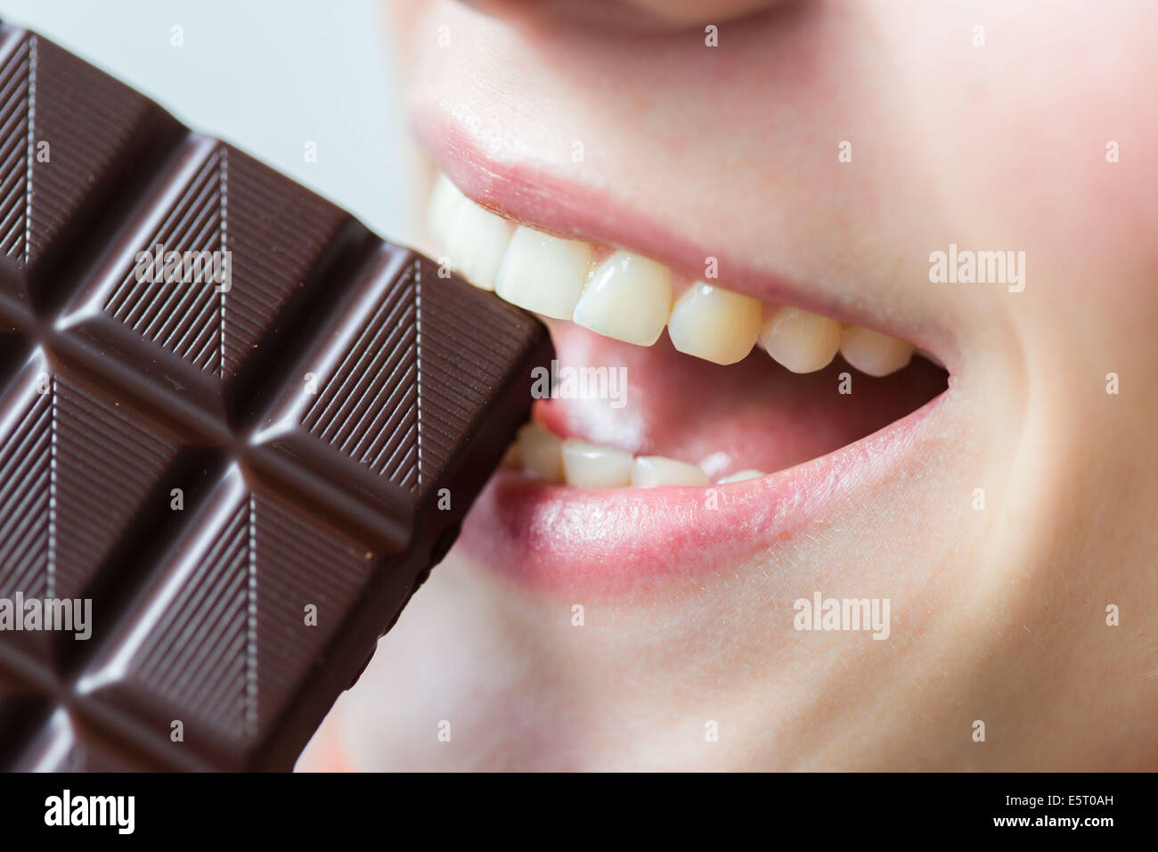 Woman eating chocolate Stock Photo - Alamy