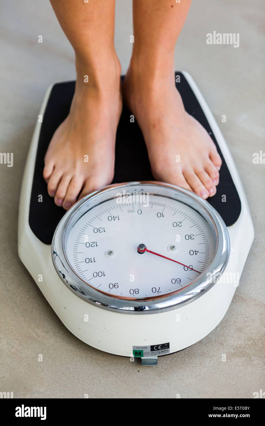 Woman standing on a scale Stock Photo - Alamy