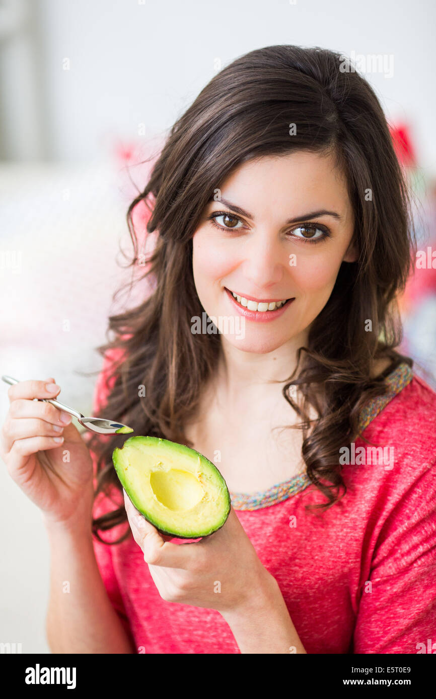 Woman eating an avocado Stock Photo - Alamy