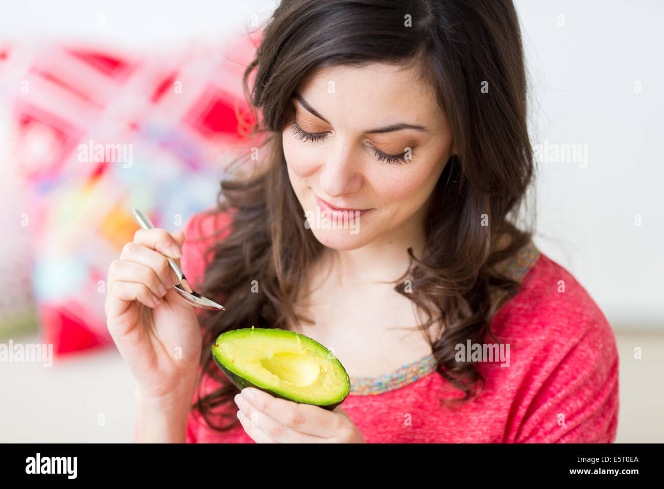 Woman eating an avocado Stock Photo - Alamy