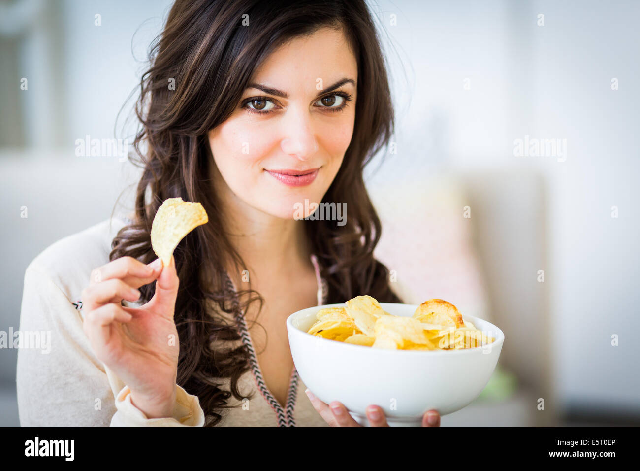 Woman eating potato chips Stock Photo - Alamy