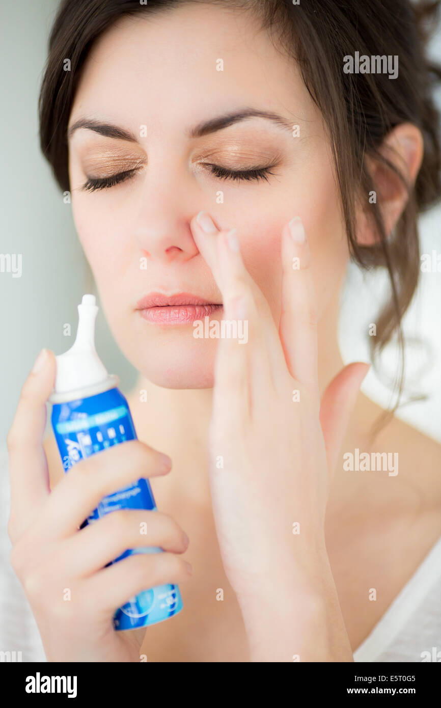 Woman using a sterile sea water spray Stock Photo - Alamy