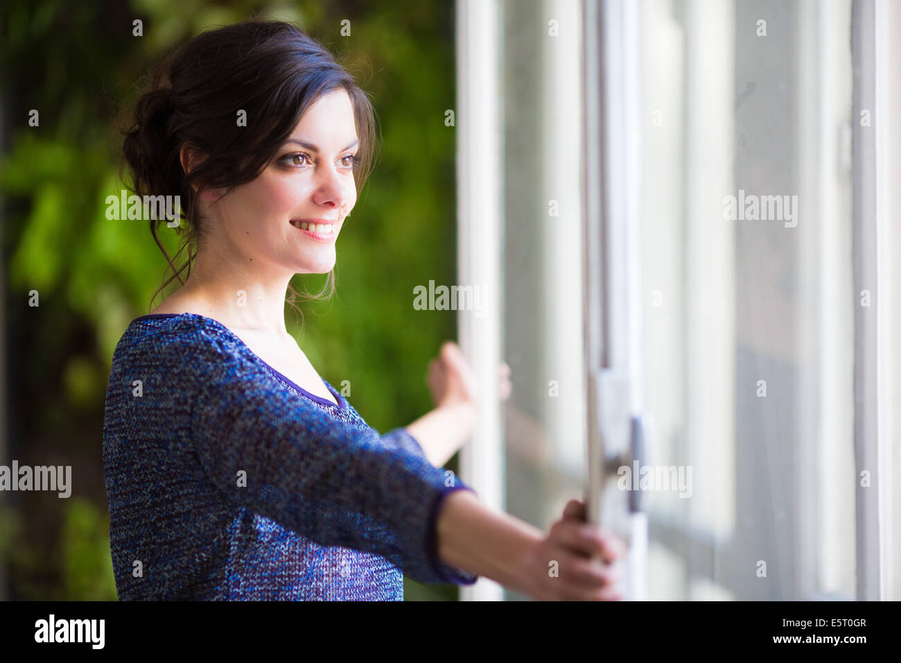 Woman opening window Stock Photo - Alamy