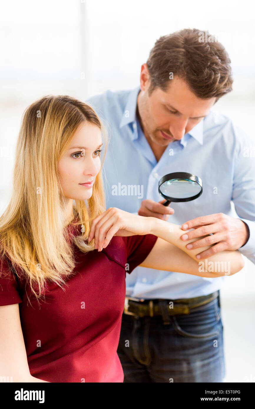 Doctor examining the skin of a woman Stock Photo - Alamy