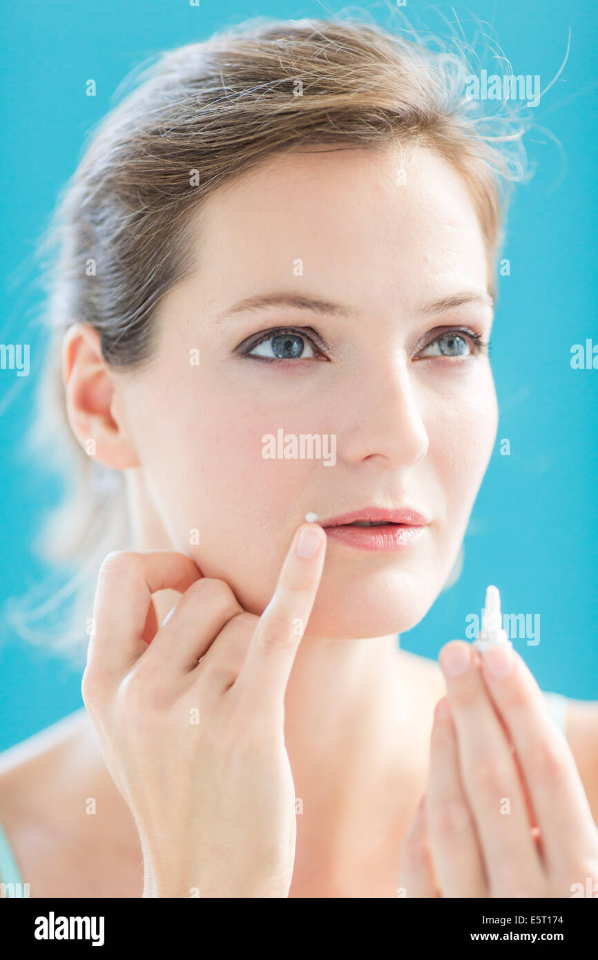Woman applying cream on her lips as a treatment for a cold sore Stock ...