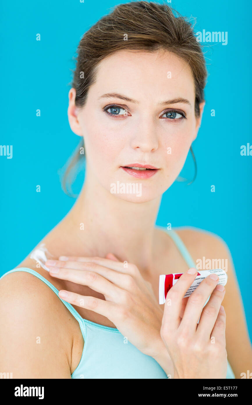 Woman applying pomade on her shoulder Stock Photo - Alamy