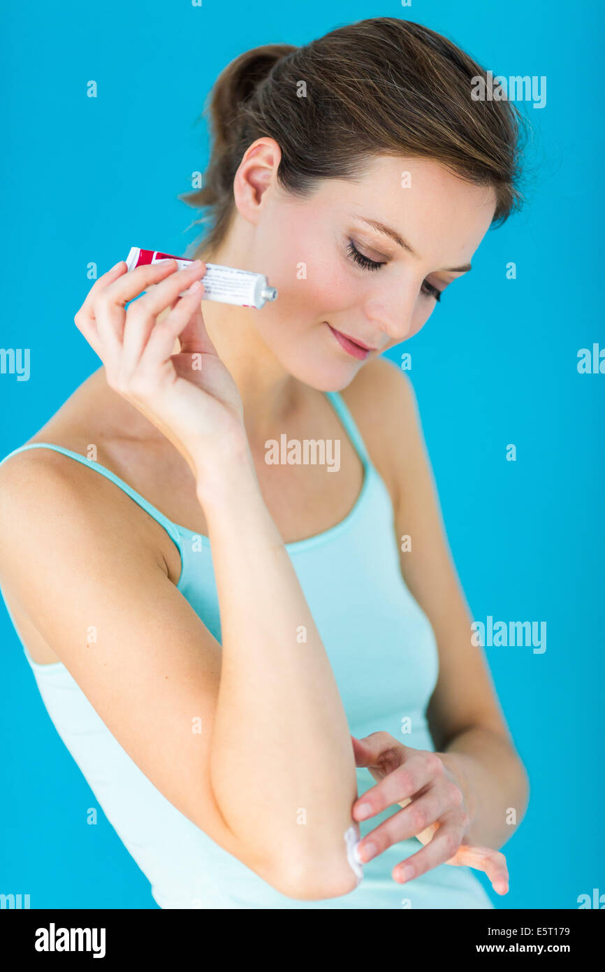 Woman applying pomade on her elbow Stock Photo - Alamy