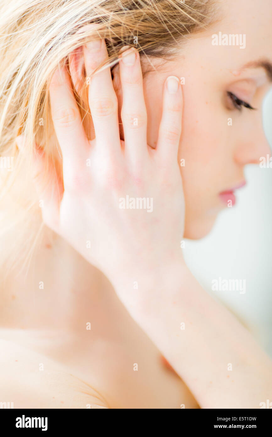 Woamn touching her ear Stock Photo - Alamy