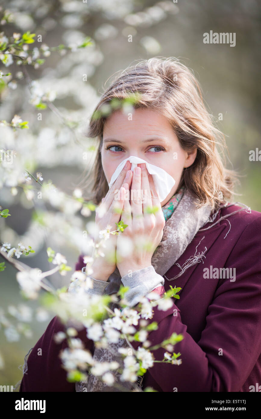 Woman with hay fever blowing her nose Stock Photo - Alamy
