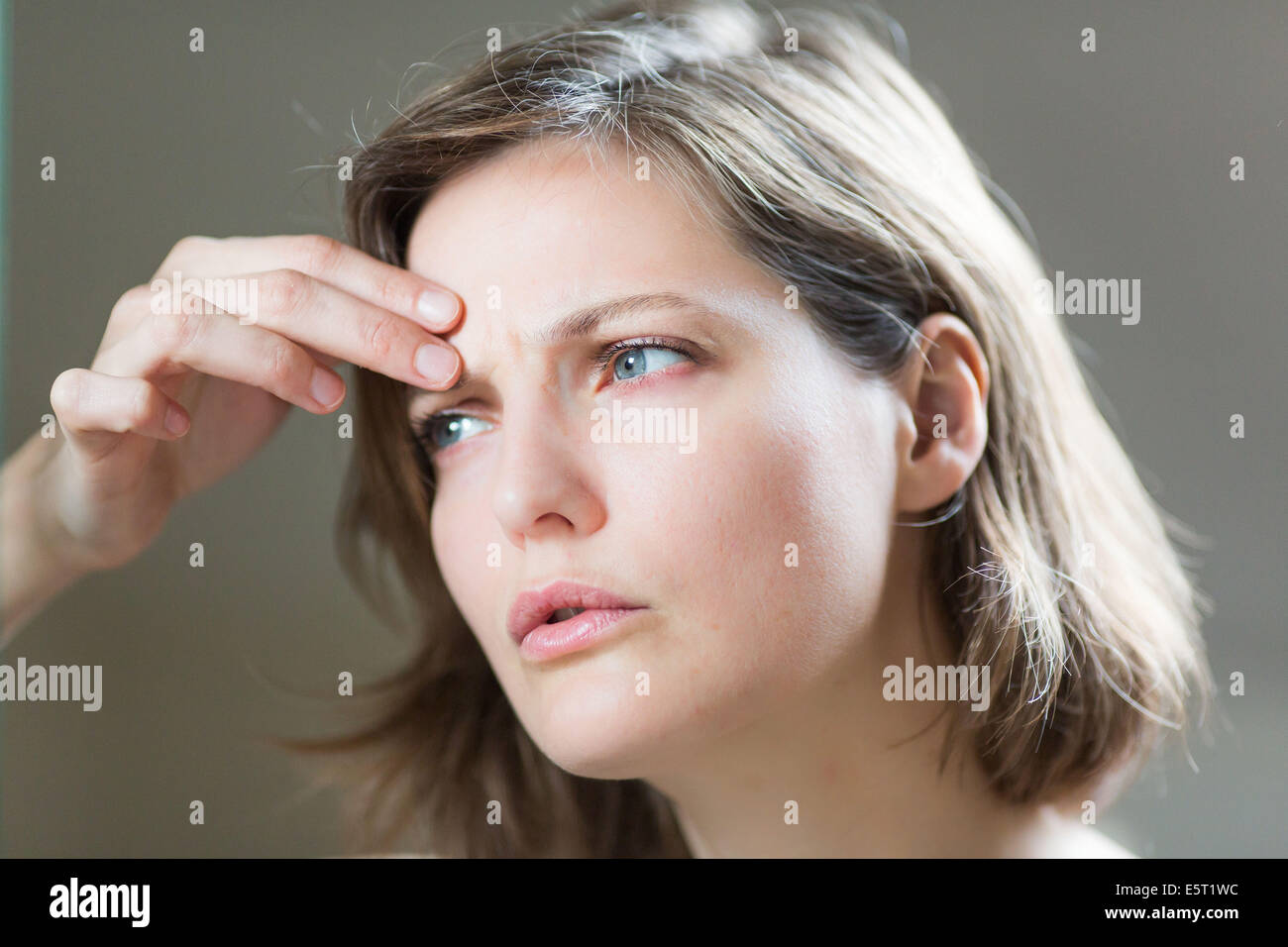 Woman checking her face in the mirror Stock Photo - Alamy